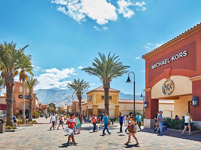 Shoppers navigate the Michael Kors intersection like seasoned explorers, maps (or shopping apps) in hand, treasures in sight.