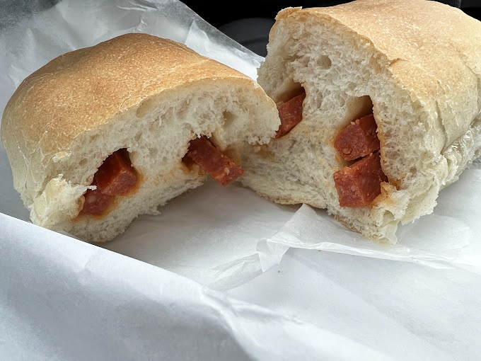 The cross-section reveals the magic: soft, pillowy bread embracing spicy pepperoni that's released its oils into the surrounding dough. It's edible architecture at its finest.
