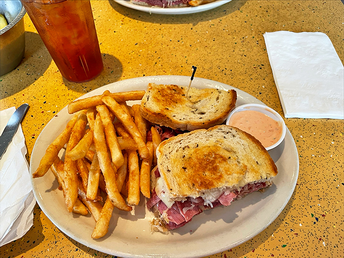 This isn't just a sandwich&mdash;it's architecture. Layers of corned beef creating the Manhattan skyline of lunch options, with crispy fries as the supporting cast.