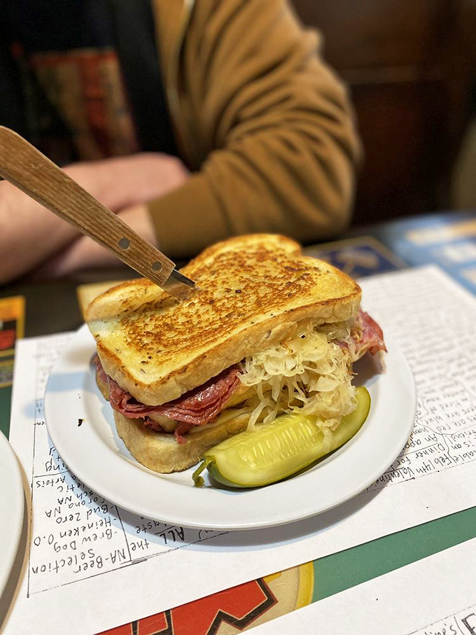 This isn't just a sandwich; it's a monument to the art of proper Reuben construction. The kind of meal that demands both hands and several napkins.