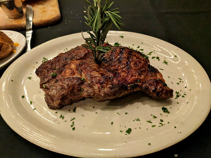 This isn't just a steak&mdash;it's a ribeye masterpiece with a sprig of rosemary standing proudly like a flag planted on delicious territory.