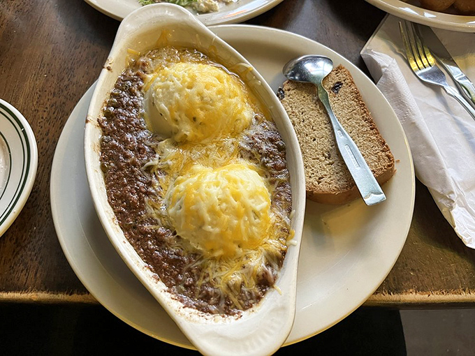 The legendary shepherd's pie arrives like comfort in a boat&mdash;two golden-topped potato islands rising from a savory sea of beef, carrots, and peas.
