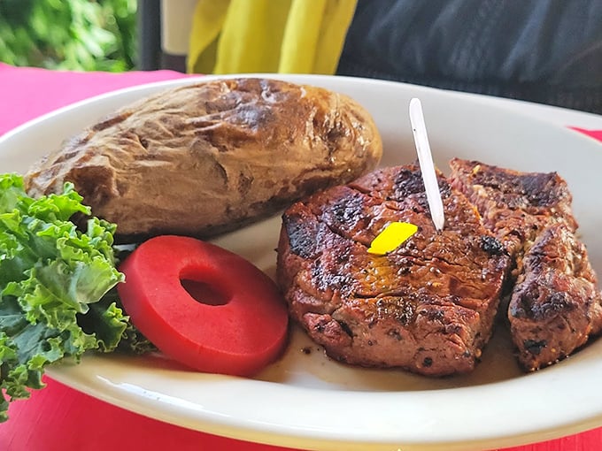 Behold the perfect partnership: a juicy steak with a pat of butter slowly melting into beefy perfection alongside a baked potato waiting for your fork.