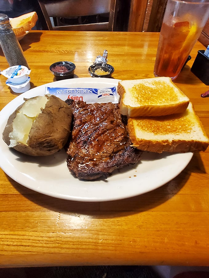 Behold the holy trinity of steakhouse perfection: a beautifully seared steak, butter-soaked baked potato, and Texas toast that's actually worth filling up on.