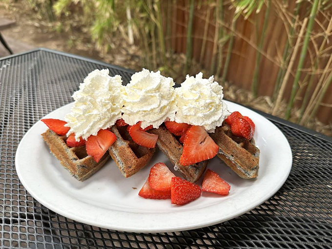 These buckwheat waffles topped with fresh strawberries and whipped cream aren't just breakfast—they're edible architecture with a berry-good foundation.