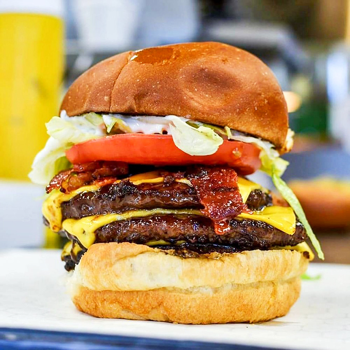 Behold the Sky Hi in all its glory—where beef patties, melted cheese, and fresh veggies create a tower of deliciousness that demands a strategic first bite.