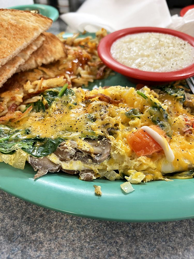 This isn't just an omelet; it's a colorful celebration on a plate. Spinach, cheese, and veggies dancing together in perfect eggy harmony.