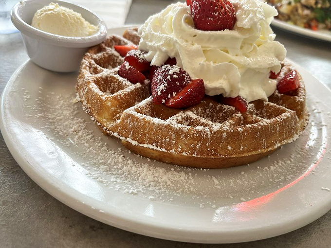 Behold the waffle of your dreams: golden, crisp, and crowned with strawberries and whipped cream. Breakfast or dessert? The correct answer is "Yes."
