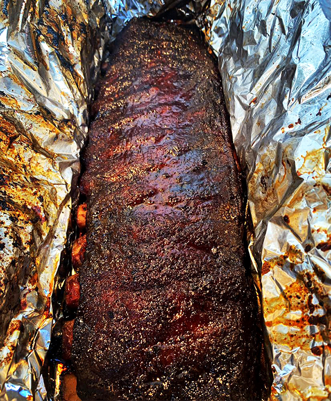 Behold the carnivore's dream &ndash; ribs with a bark so perfect it should be in a museum. That pink smoke ring is nature's way of saying "you're welcome."