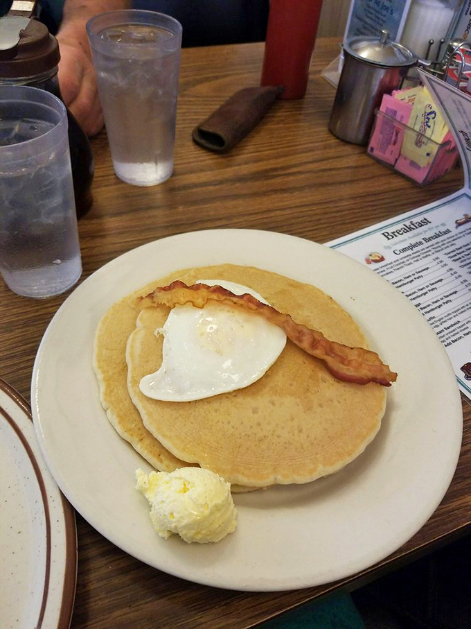 Breakfast nirvana achieved: pancakes with a perfectly fried egg and crispy bacon creating the holy trinity of morning meals.