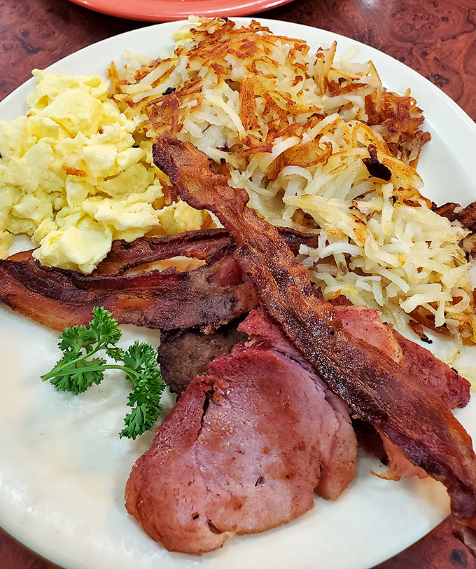 Breakfast nirvana achieved: perfectly crisp bacon, fluffy scrambled eggs, and hash browns that crackle with each heavenly bite.