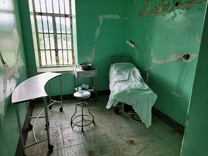 The asylum's grounds feature a serene fountain and manicured gardens, a stark contrast to the institutional life within. Patients once strolled these paths seeking moments of peace. 