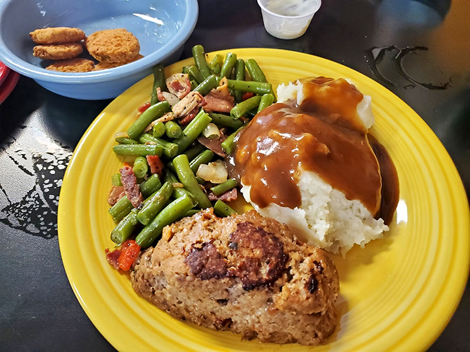 Comfort food paradise: Where green beans dance with bacon, meatloaf sings with gravy, and mashed potatoes provide the perfect buttery bed for it all.
