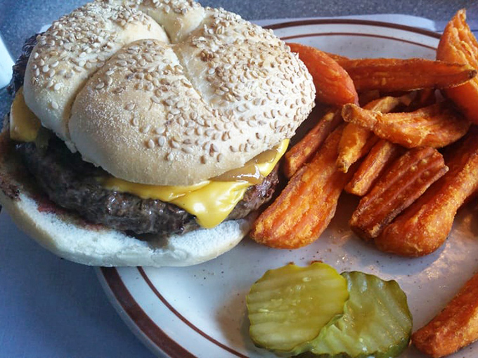 This isn't just a cheeseburger; it's edible nostalgia on a sesame seed bun. The sweet potato fries and pickle spear complete this perfect plate.
