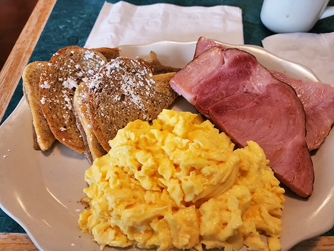 Classic breakfast perfection doesn't need fancy plating &ndash; just perfectly scrambled eggs, ham sliced thick enough to mean business, and French toast dusted with powdered sugar. 