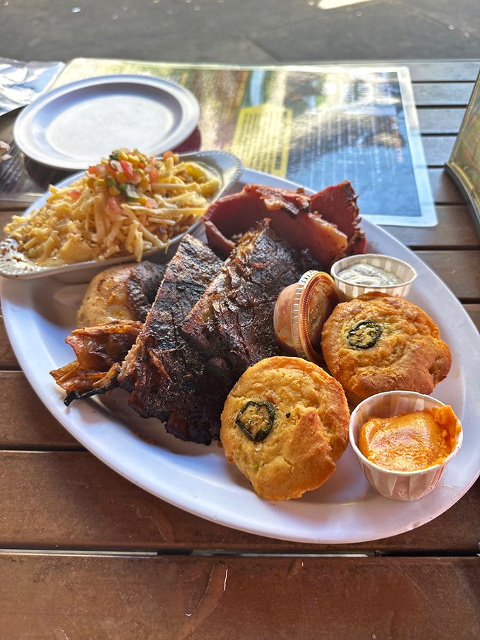 Behold the barbecue platter of dreams: ribs with that perfect bark, cornbread that would make a Southerner weep, and sides that refuse to be upstaged.