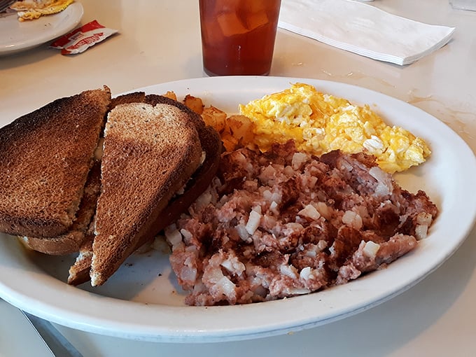 Behold the holy trinity of breakfast perfection: crispy corned beef hash, fluffy scrambled eggs, and toast ready for yolk-sopping duty.