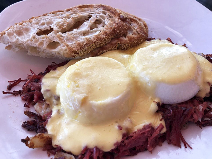 Heaven on a plate: Perfectly poached eggs doing the backstroke in hollandaise atop a crimson sea of corned beef hash. Resistance is futile.