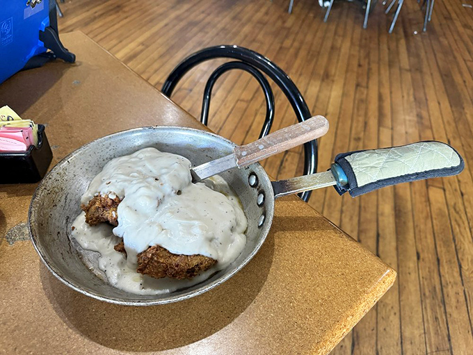 The country fried steak arrives like a work of art—golden-brown crust swimming in creamy pepper gravy. This isn't just food; it's edible therapy.
