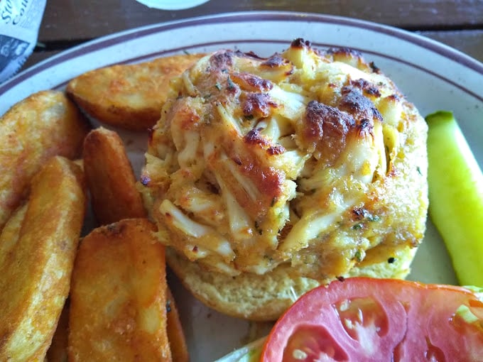 Behold the Maryland masterpiece—a golden-brown crab cake that's more crab than cake, perched proudly like the state's edible crown jewel.
