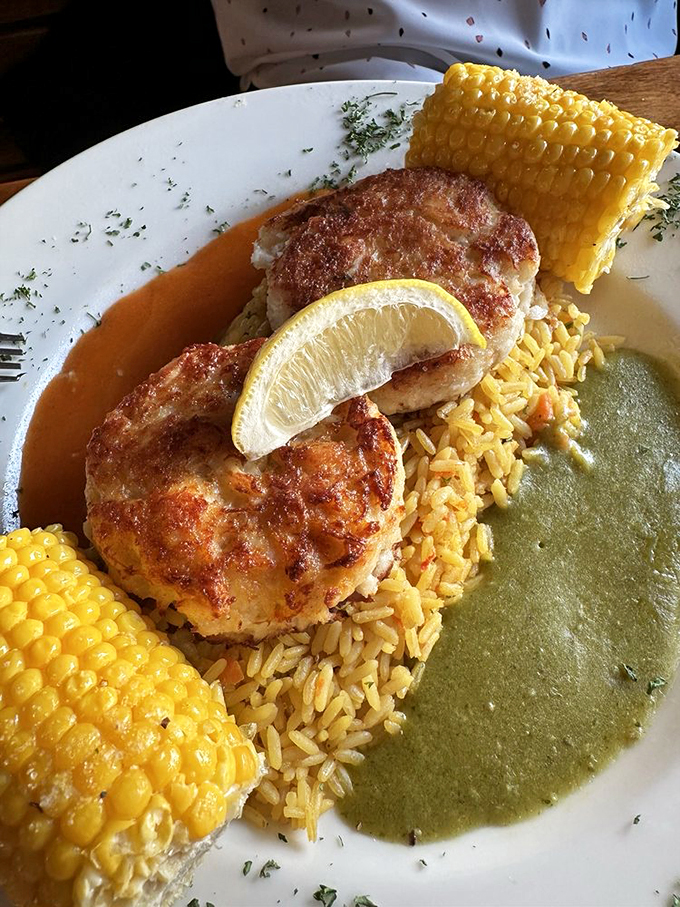 Golden-brown crab cakes with sweet corn on the cob - proof that sometimes the simplest combinations create the most profound food memories.