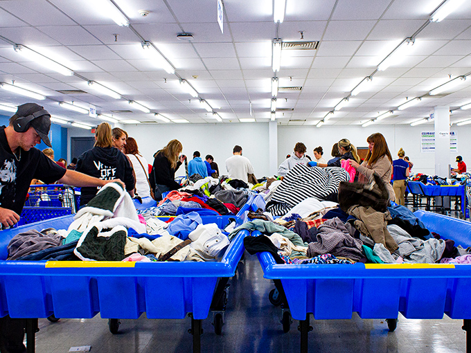 The blue bins: where ordinary shoppers transform into archaeologists, carefully excavating through layers of textile history for hidden gems.
