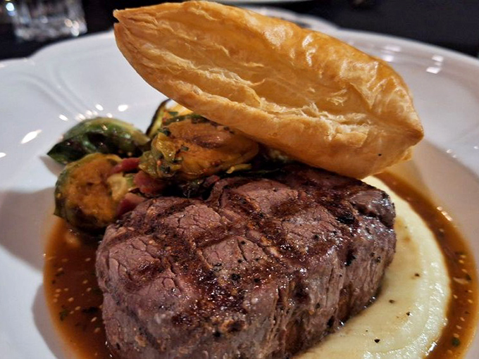 Steak perfection doesn't need fancy tricks. This filet mignon rests on a cloud of creamy sauce with a pastry crown that says, "Yes, we're showing off a little." 