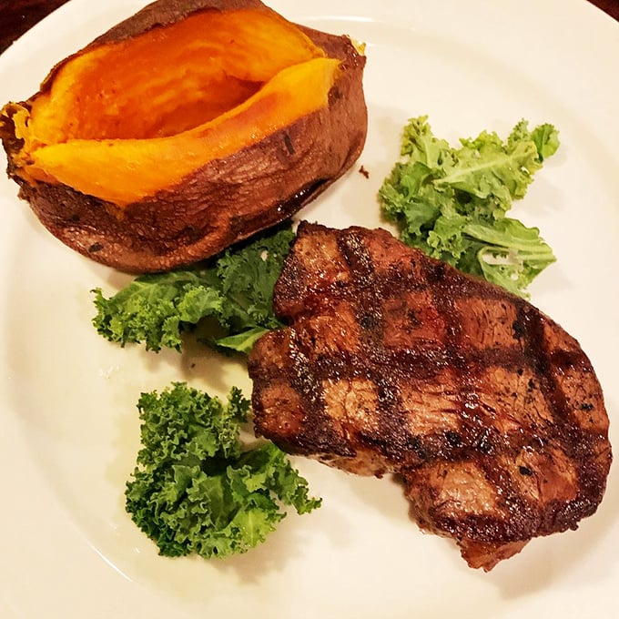 A perfectly char-grilled steak alongside a sunset-hued sweet potato—this plate doesn't just satisfy hunger, it fulfills destinies.