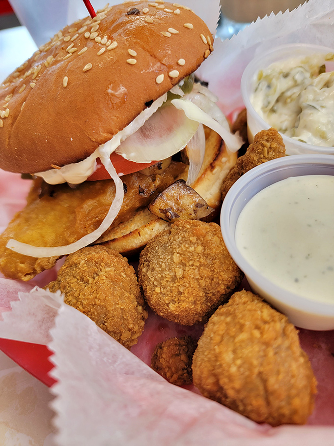 Behold the sandwich that launches a thousand road trips. Golden-fried perfection nestled in a sesame seed bun, with crispy mushrooms standing guard alongside.