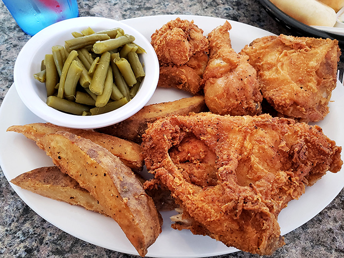 Golden-brown perfection that makes your mouth water just looking at it. This isn't just fried chicken&mdash;it's edible artwork with a side of potato wedges and green beans.