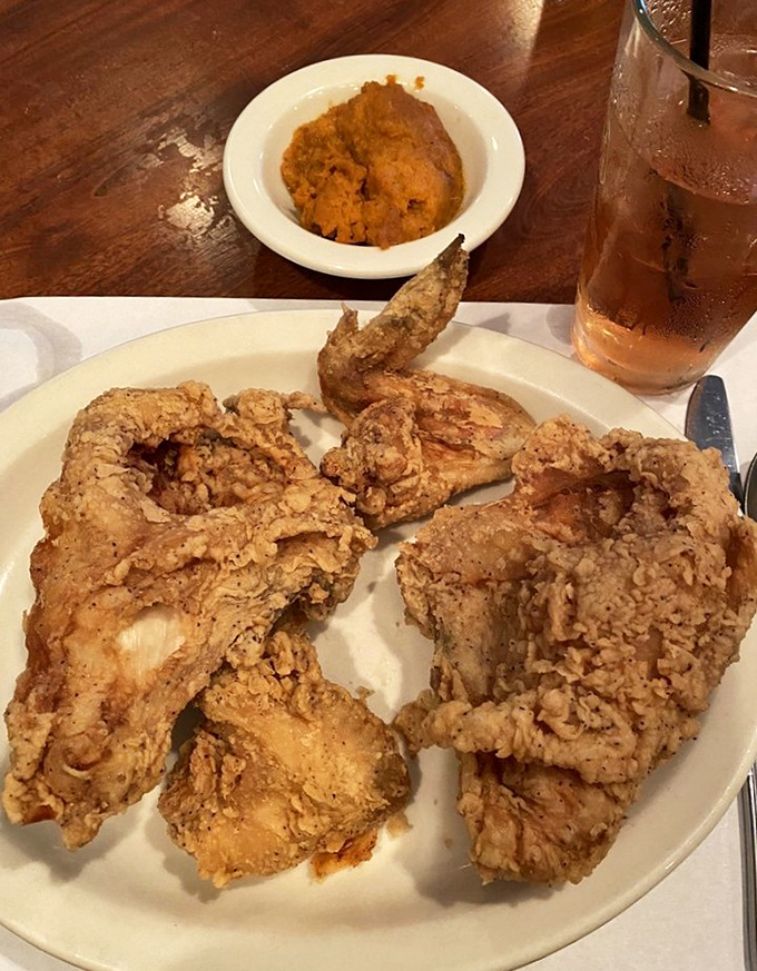 Golden treasure on a plain white plate&mdash;this isn't just fried chicken, it's an edible time machine to when calories didn't count and crispy skin was considered a basic human right.