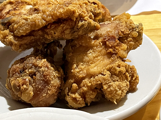 Golden-brown pieces of fried chicken stacked like edible Jenga blocks, with a crust so crispy you can practically hear it crunch through the photo.