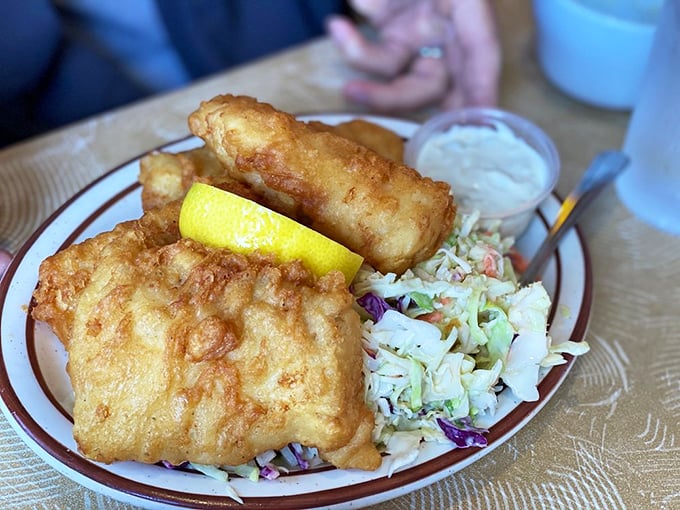 Golden-battered fish that shatters with each bite, nestled beside crisp coleslaw&mdash;proof that sometimes the simplest pleasures are the most profound.