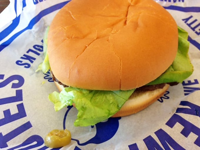 Behold the classic Kewpee burger in all its glory&mdash;crisp lettuce, a perfectly round bun, and that signature olive peeking out like it knows something you don't.