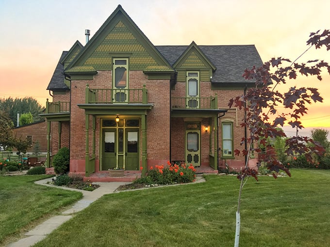 This Victorian brick home with its distinctive green trim captures that magical moment when sunset bathes historic architecture in a warm, golden glow.