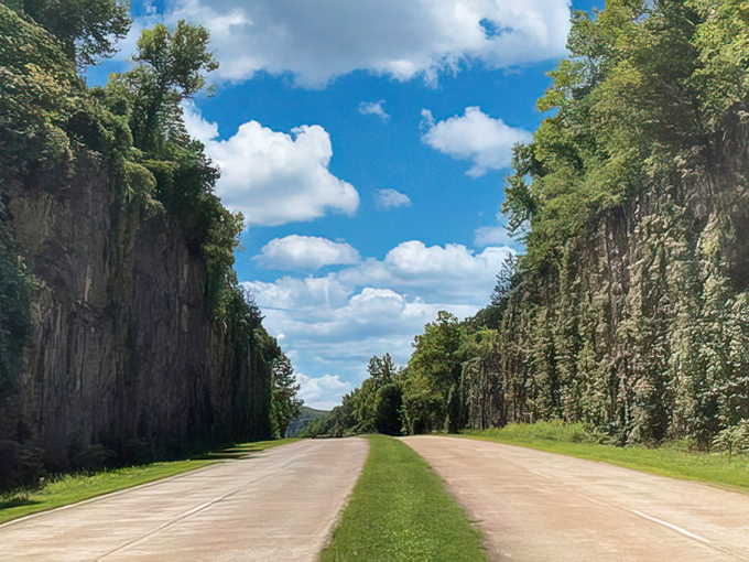 Highway through rock-cut cliffs, where the road itself becomes the destination. Nature stepped aside to let America's highway pass through.