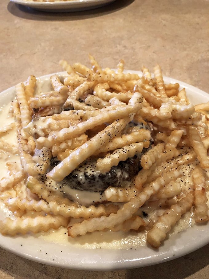 Behold the legendary horseshoe in its natural habitat! Crinkle-cut fries swimming in cheese sauce atop a burger&mdash;a monument to the "diet starts tomorrow" philosophy.