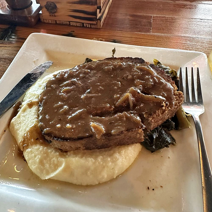 Behold the star of the show: meatloaf bathed in caramelized onion gravy atop creamy mashed potatoes. Grandma would be jealous&mdash;and impressed.