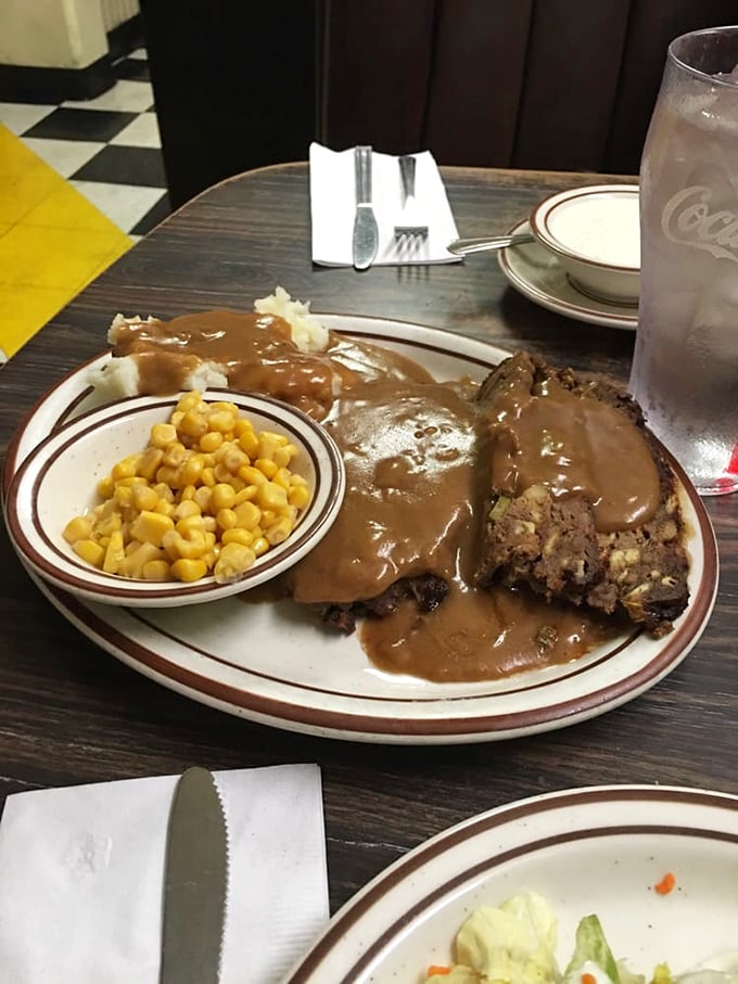 Behold the star of our show: meatloaf swimming in gravy with a side of sunshine-yellow corn. Comfort food that hugs your insides.