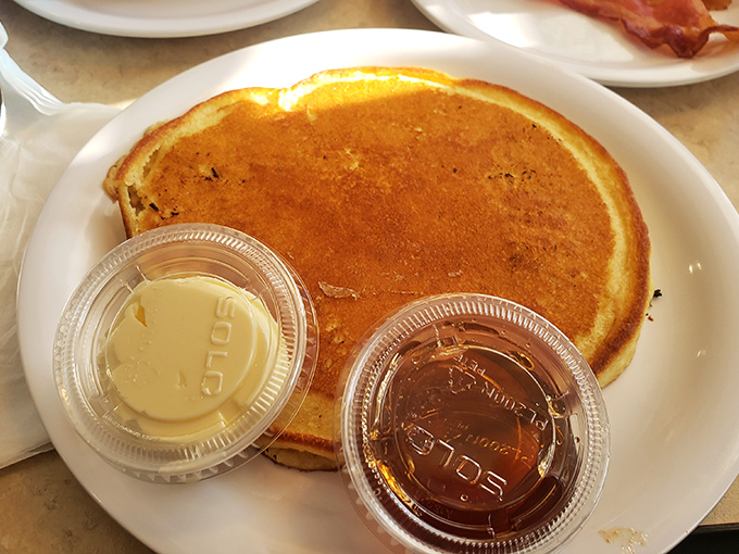 Behold the pancake in its natural habitat &ndash; golden-brown, perfectly round, and flanked by butter and syrup soldiers ready for duty.
