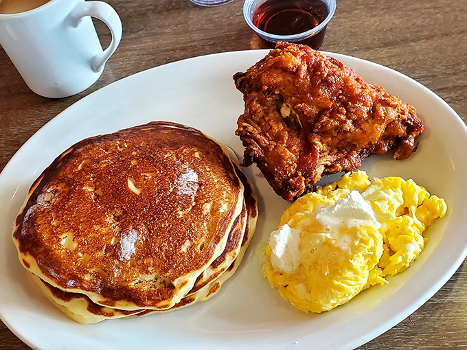 This isn't just breakfast&mdash;it's edible architecture. That golden pancake, crispy chicken, and those eggs are the holy trinity of morning salvation.