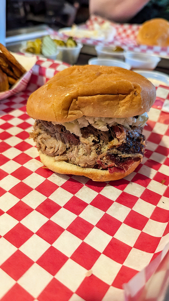 The pulled pork sandwich arrives like a meaty mountain on a bun, with bark so beautiful it could make a tree jealous.