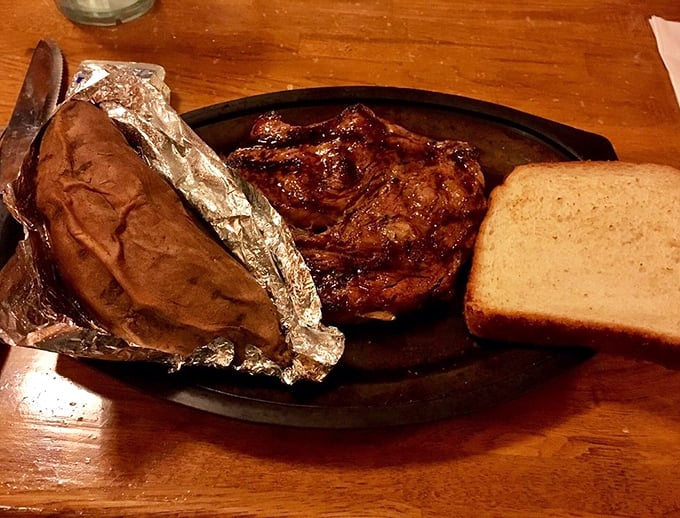 This isn't just a steak; it's a sermon on simplicity—perfectly seared ribeye with a jacket potato and bread that doesn't need fancy plating to impress.