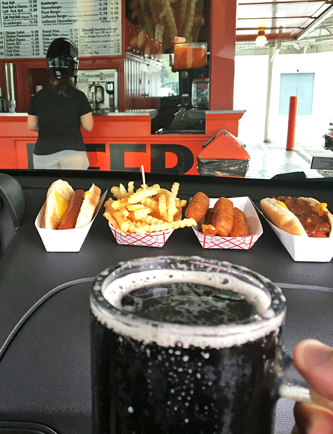 Car dining at its finest&mdash;hot dogs, fries, and that legendary root beer creating the perfect dashboard picnic. Who needs a fancy table when you've got a steering wheel?