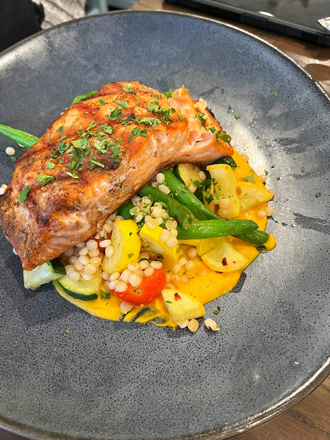 This perfectly seared salmon perched atop a colorful medley of vegetables isn't just dinner&mdash;it's edible artwork that happens to taste even better than it looks.