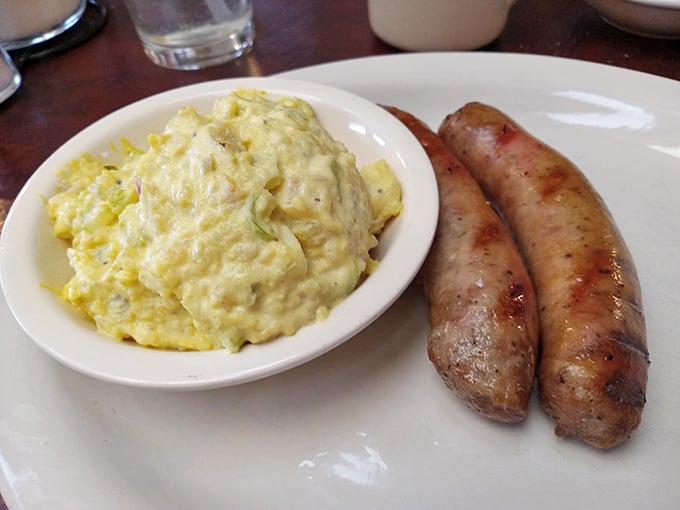 Breakfast sausage links that could make a vegetarian question their life choices, paired with potato salad that grandmothers dream of making.