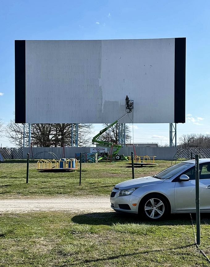 Maintenance in action! The massive screen receives some TLC before the season begins, with a playground peeking out below.