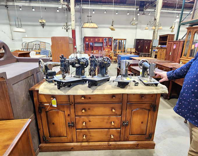 Vintage sewing machines lined up like a mechanical choir on an antique dresser. Each one stitched together someone's life story.
