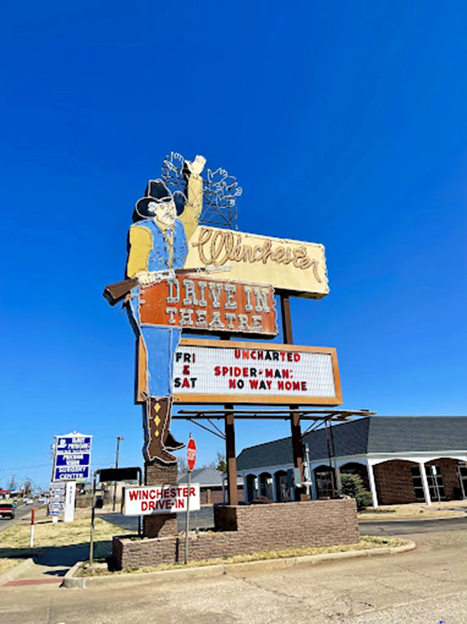 The Winchester's iconic cowboy marquee stands tall against the Oklahoma sky, a neon-lit sentinel guarding the gateway to celluloid dreams.