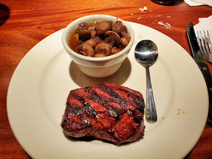 A perfectly seared steak alongside mushrooms that have clearly found their life's purpose. Meat and mushrooms: a love story.